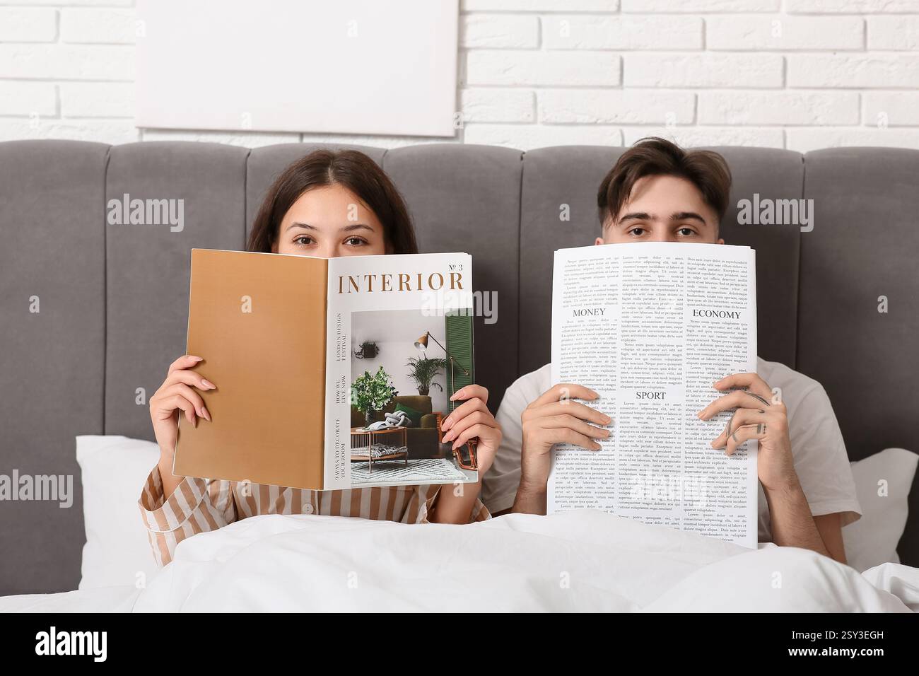 Young couple reading magazines together in bed Stock Photo - Alamy