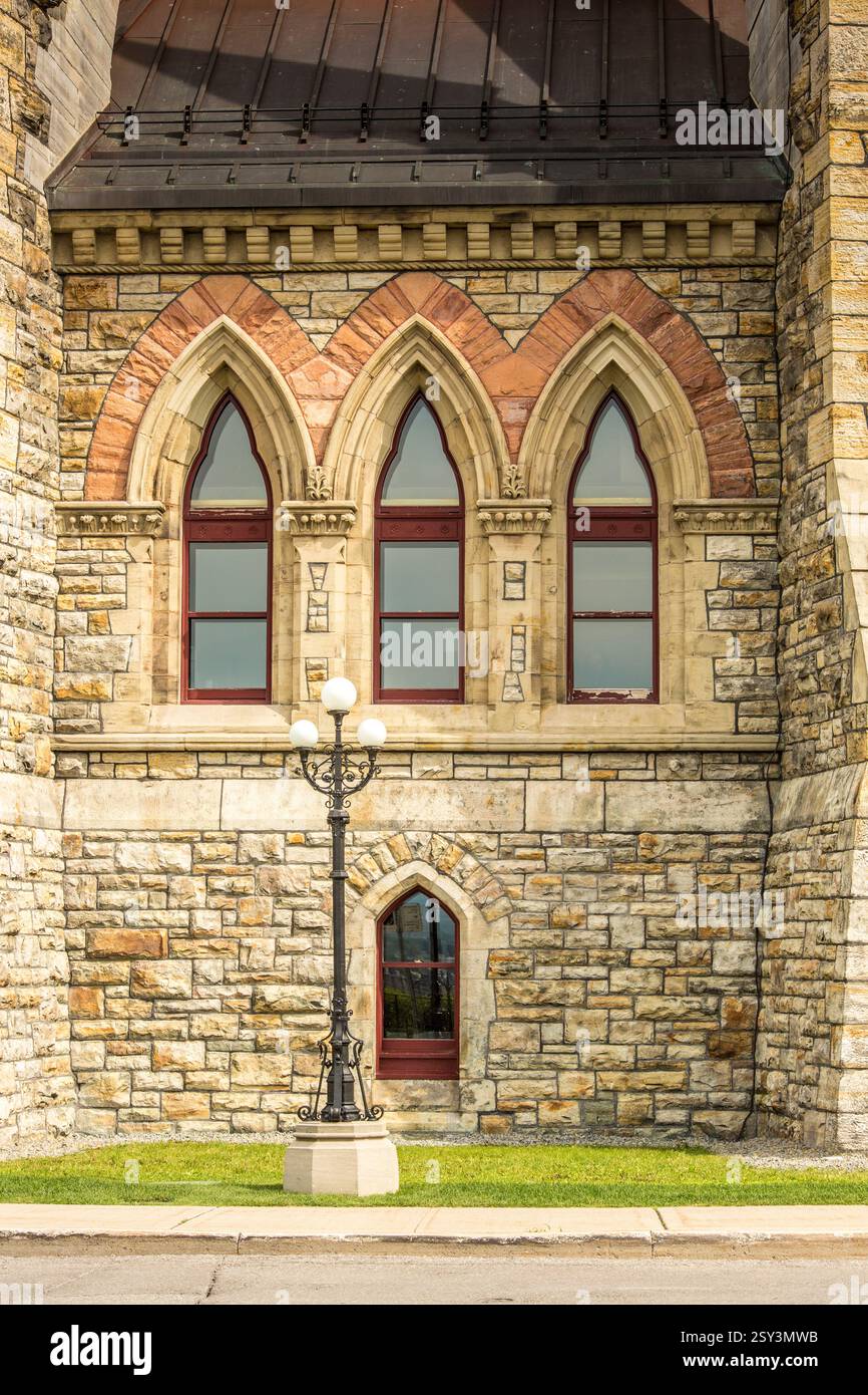 Brick building with three arched windows. A street lamp is in front of ...