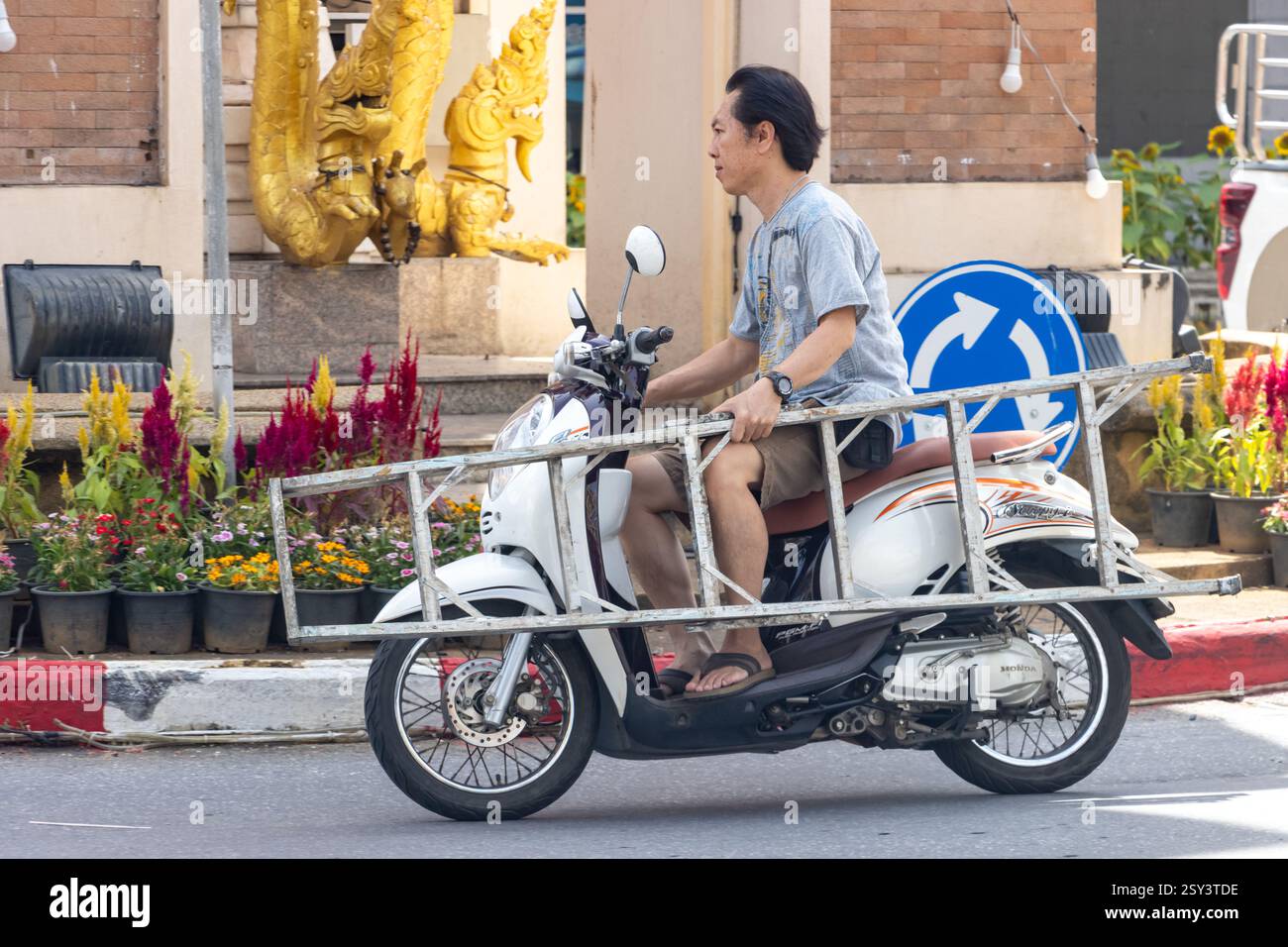 BETONG, THAILAND, MAR 02 2024, Man carry an aluminum stepladder on a ...