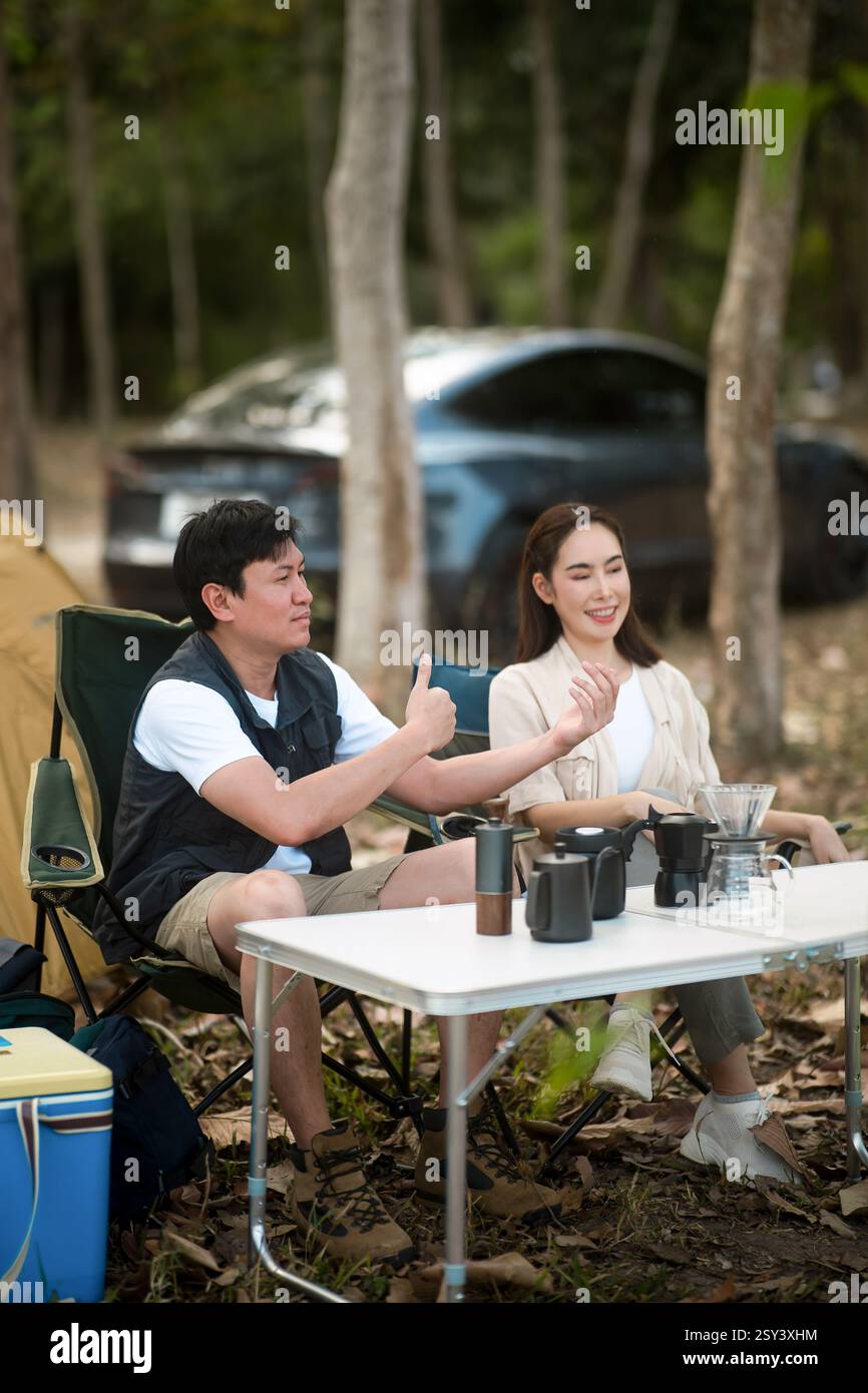 The man is explaining or telling a story to a smiling woman while ...