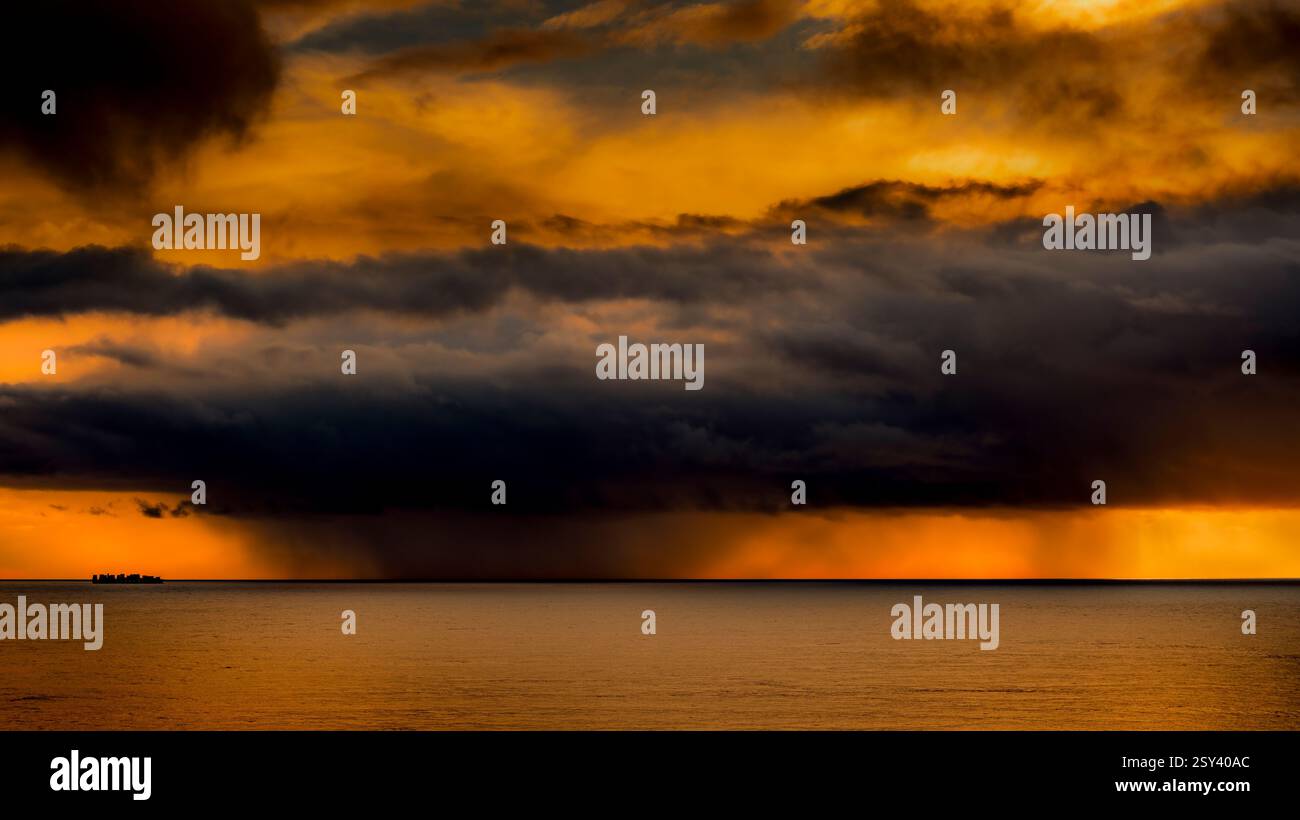 Amazing cloudscape looming over the ocean horizon carrying massive ...