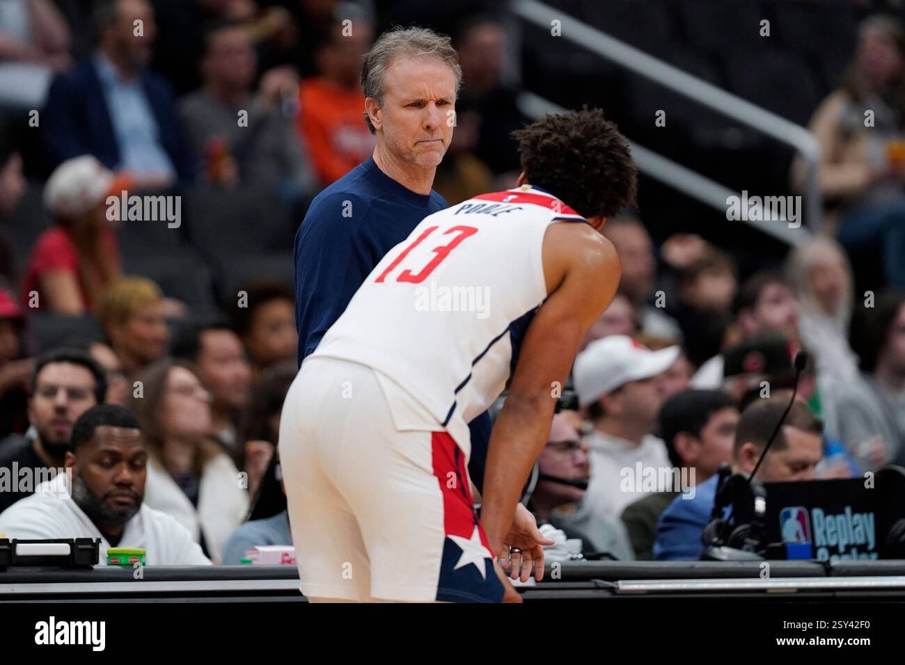 Washington Wizards head coach Brian Keefe talks with guard Jordan Poole ...
