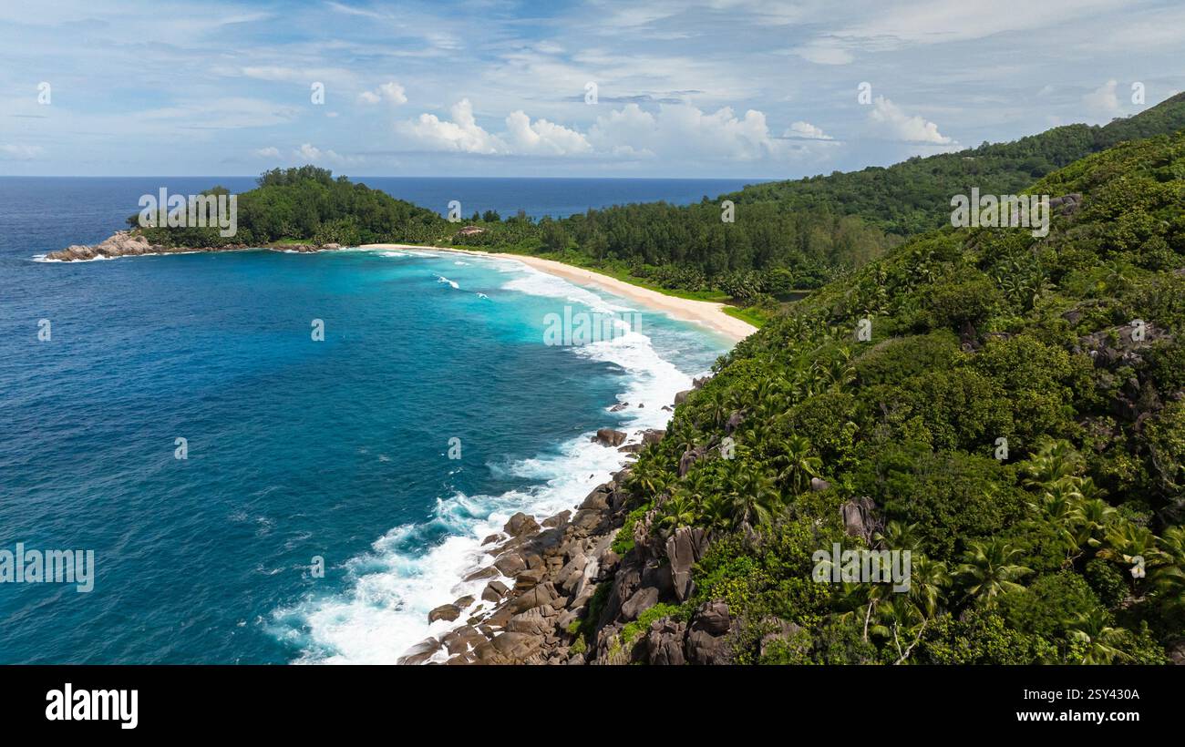 Tropical beach with turquoise waters meeting lush greenery along the ...