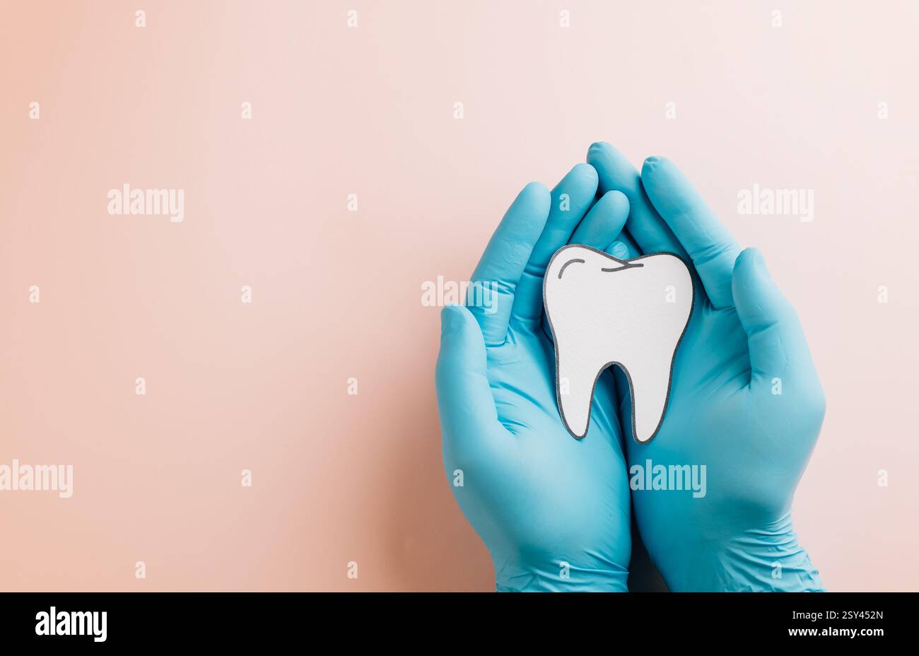 Dentist Day. Gloved doctor hands hold a tooth paper cutout on pink ...