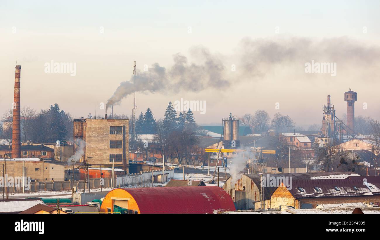 Thick smoke rises from factory chimneys in a small town, causing air ...
