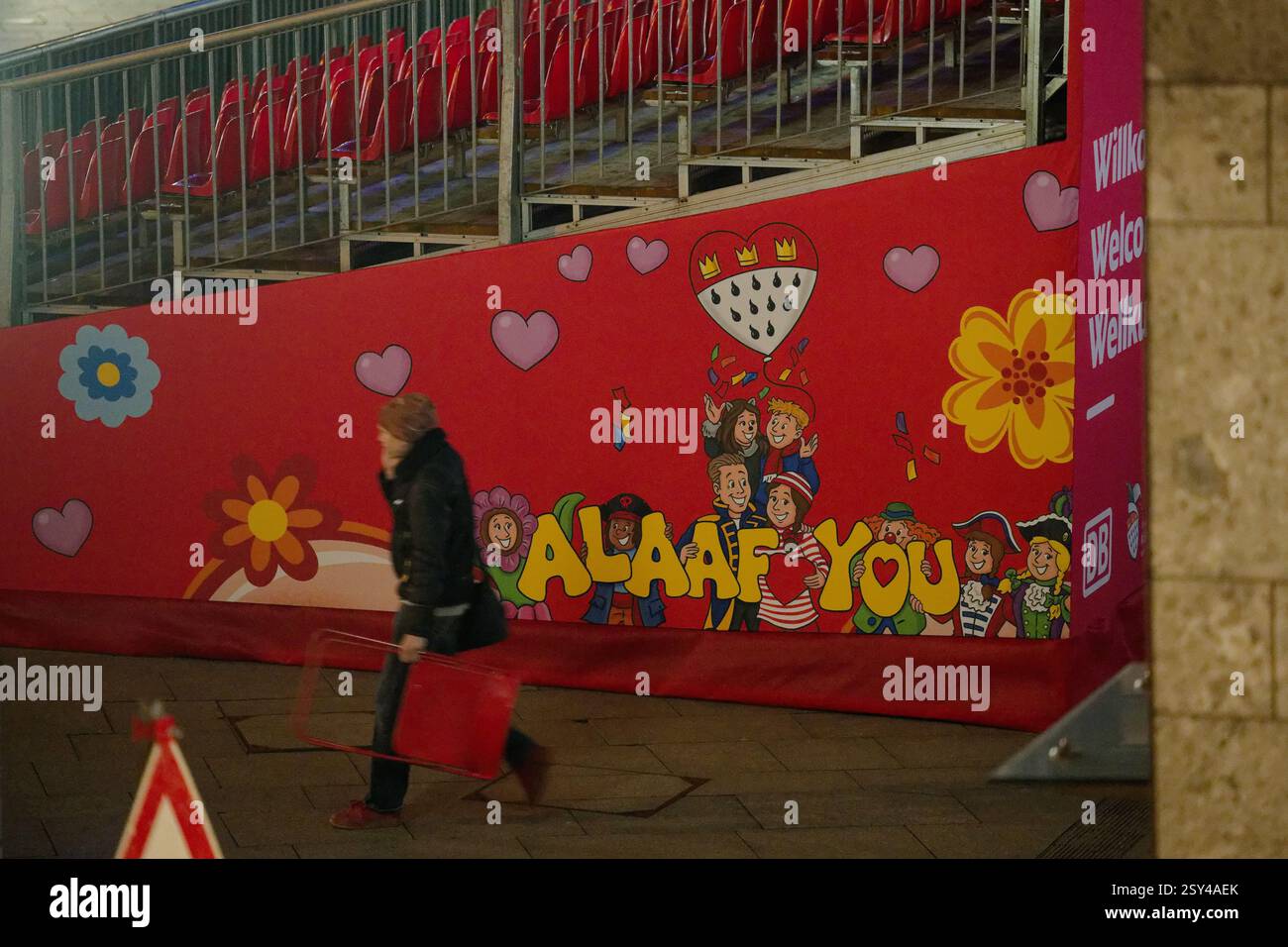 Cologne, Germany. 27th Feb, 2025. A passer-by passes a grandstand for ...