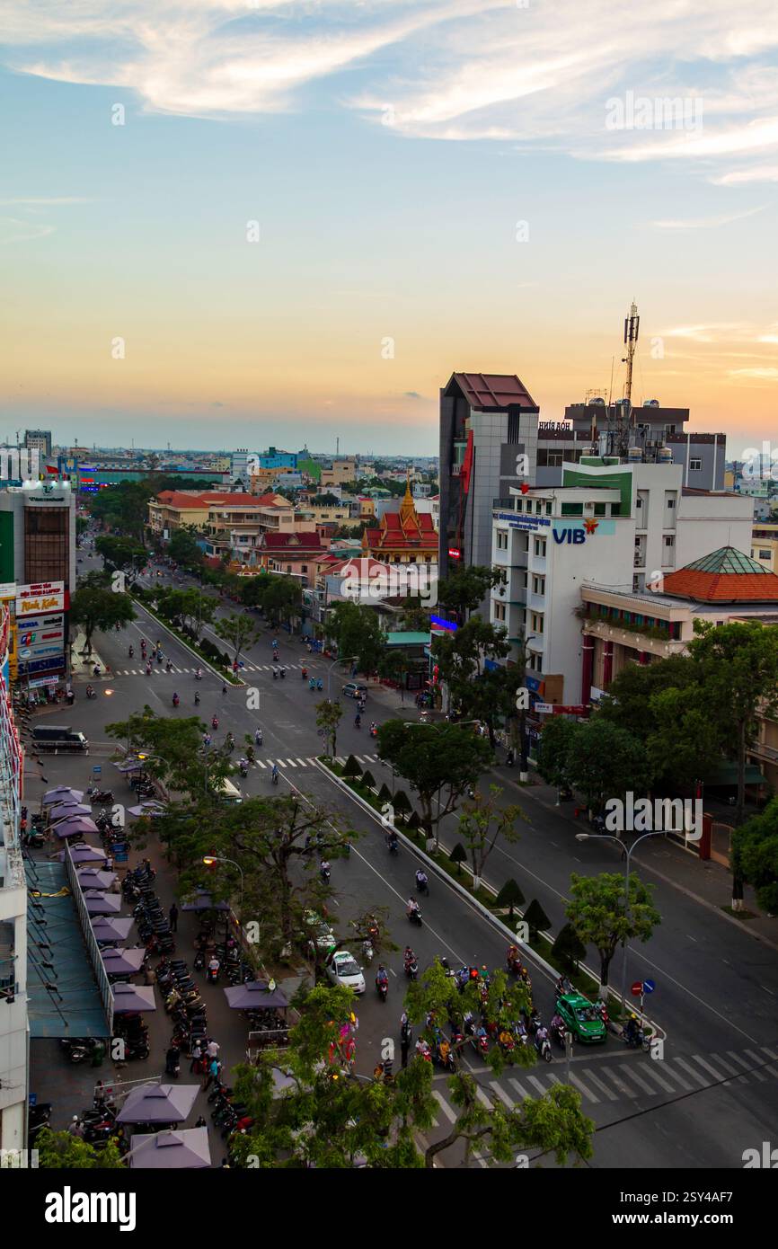 cityscape buildings streets setting sun colour white patchy clouds ho ...