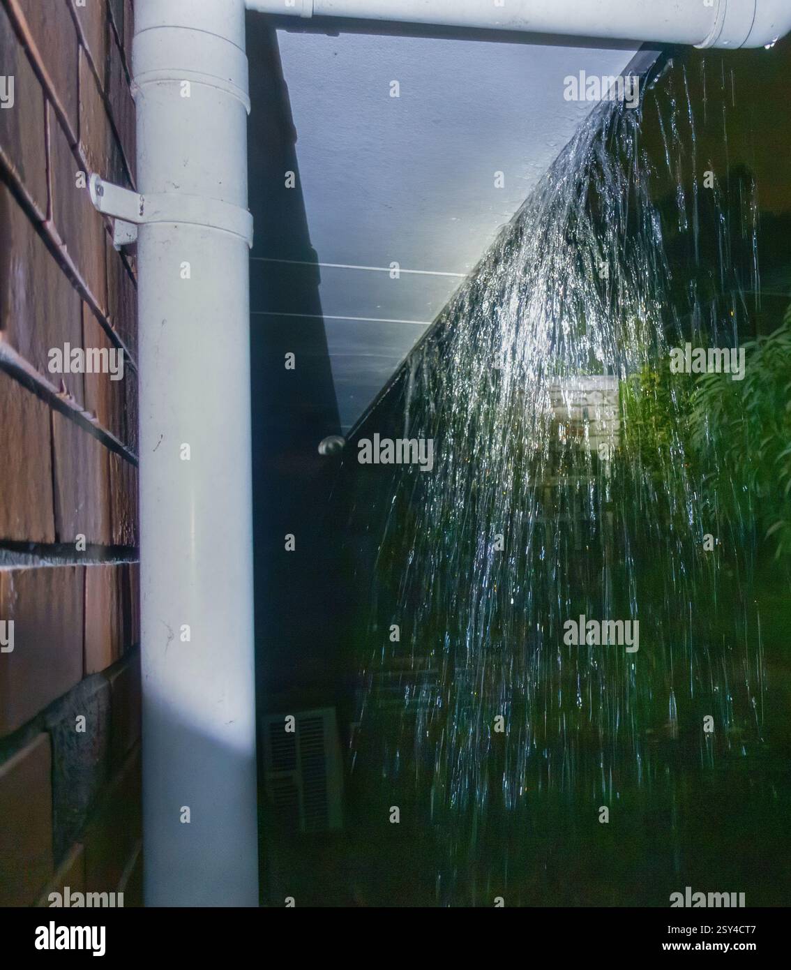 Gutter overflow during the heavy rain at night. Vertical format Stock ...
