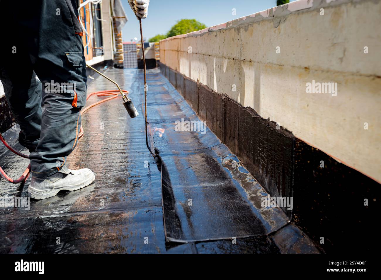 Worker is heating, melting bitumen waterproofing installation over ...