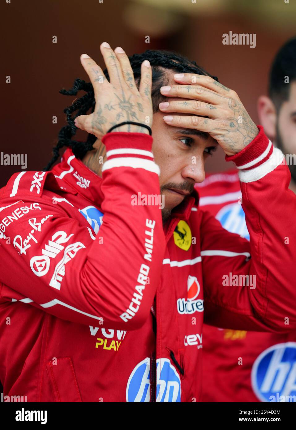 Ferrari driver Lewis Hamilton ties back his hair on day two of pre ...