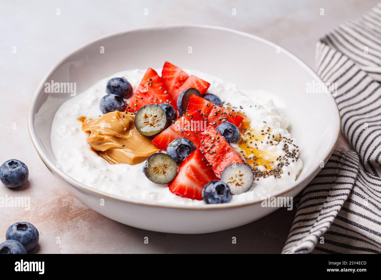 Cottage cheese with berries, peanut butter and honey, close-up. Healthy ...