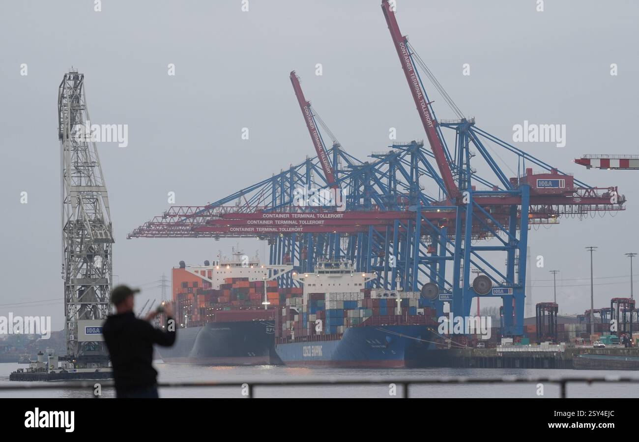 27 February 2025, Hamburg: A man photographs the harbor backdrop at the ...