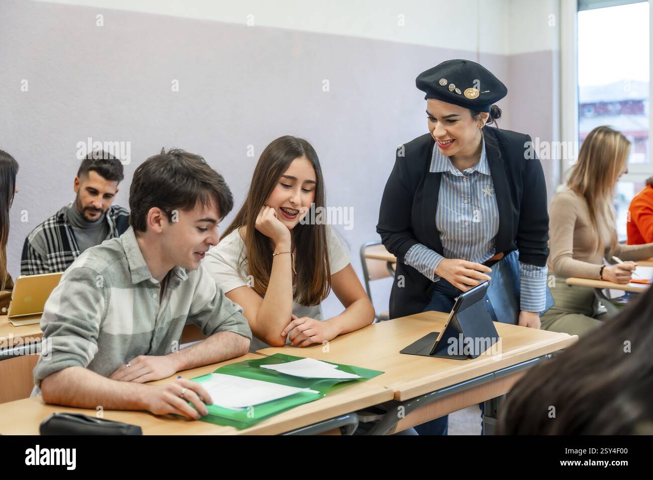 Two teenage students teacher desk hi-res stock photography and images ...
