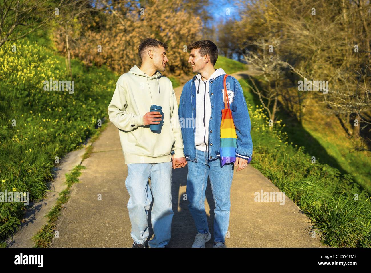 Young Caucasian Gay Couple Holding Hands And Walking In A Park