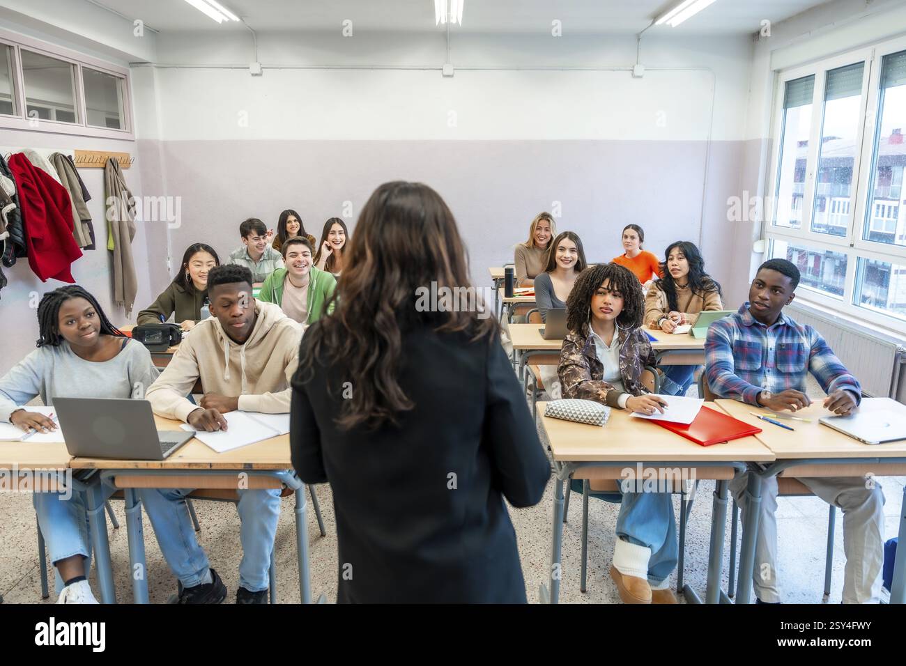 Female professor teaching a lesson to a multi ethnic group of students ...