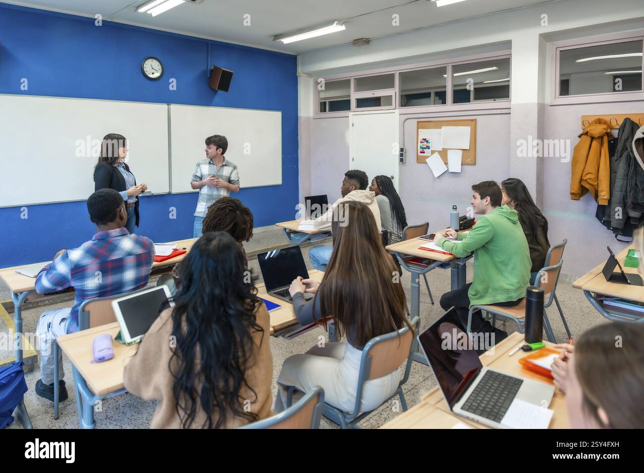 Multi ethnic group of high school students attending a lesson with two ...