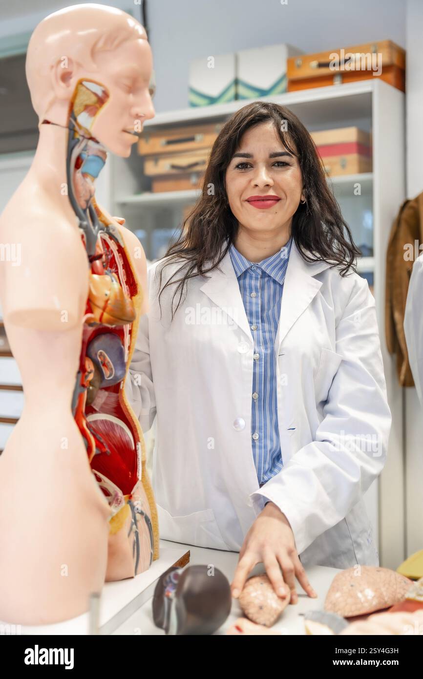 Smiling medical student pointing at anatomical model organs during ...