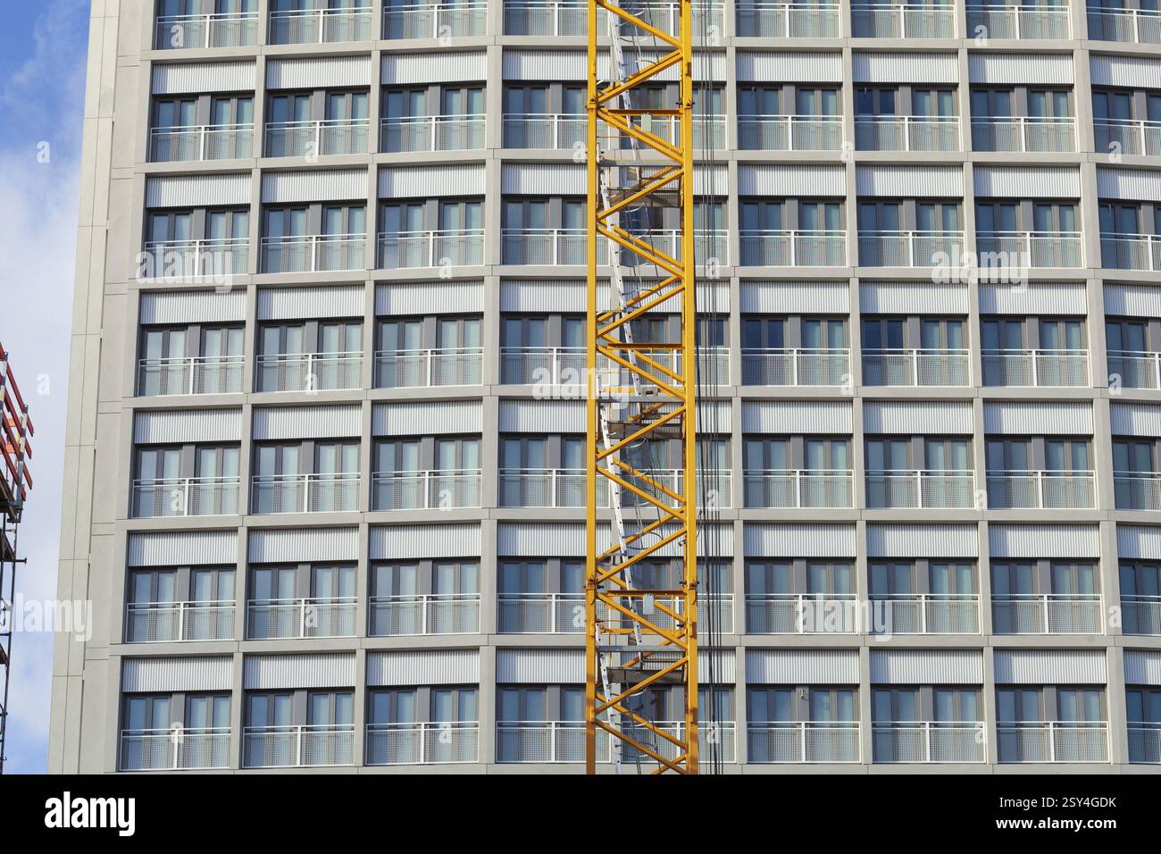 Construction crane in front of the window front of a high-rise building ...