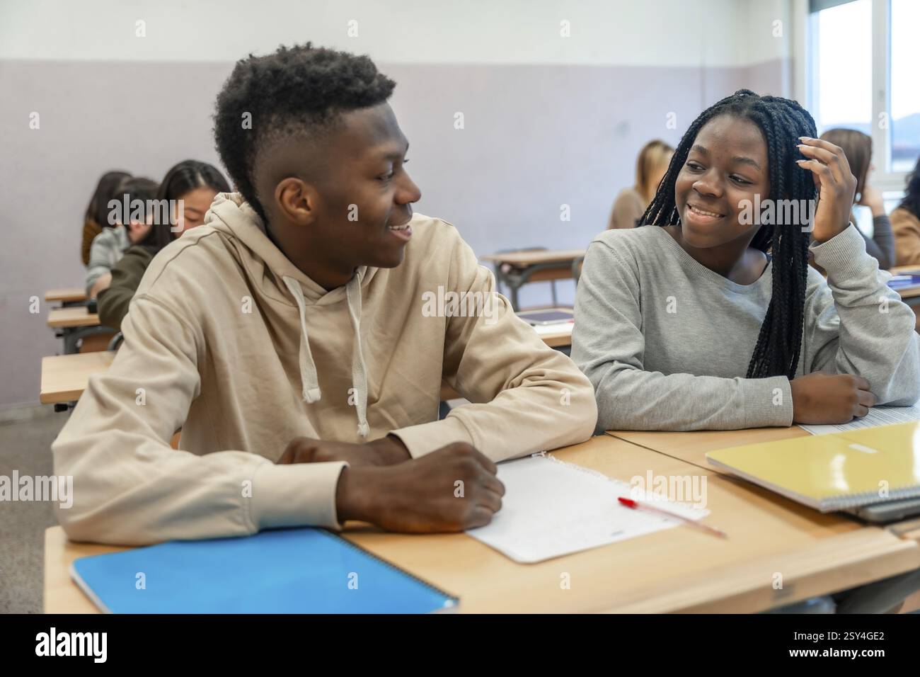 Two college students smiling and engaging in conversation during a ...