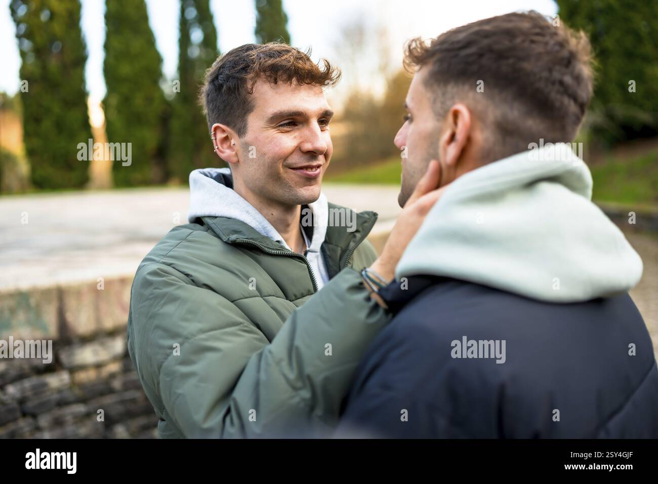Two men embracing and smiling at each other, sharing a tender moment ...