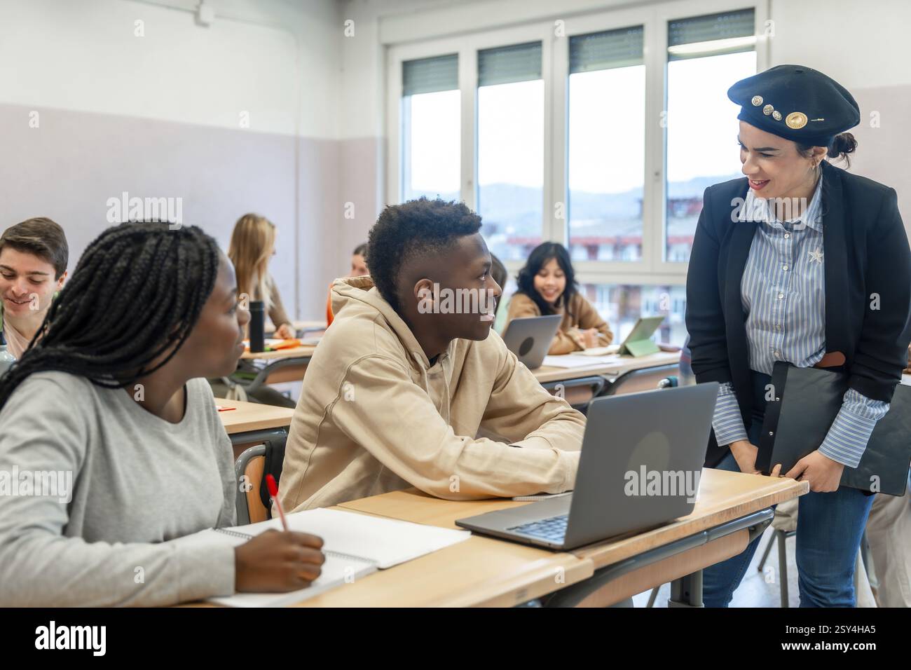 Multi ethnic students listening to their teacher during a lesson in a ...