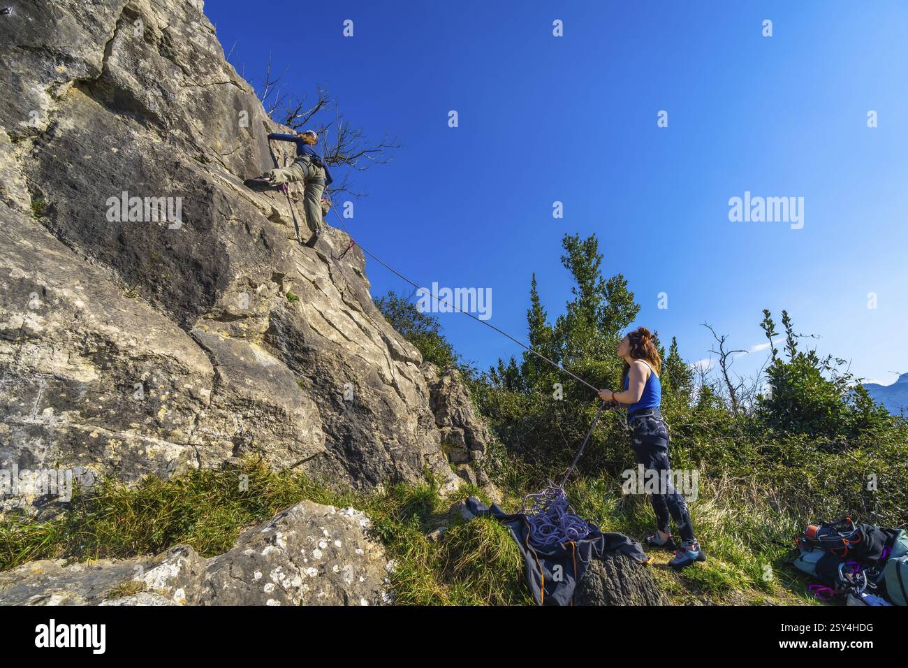 Two female rock climbers ascending a challenging rock face, enjoying a ...