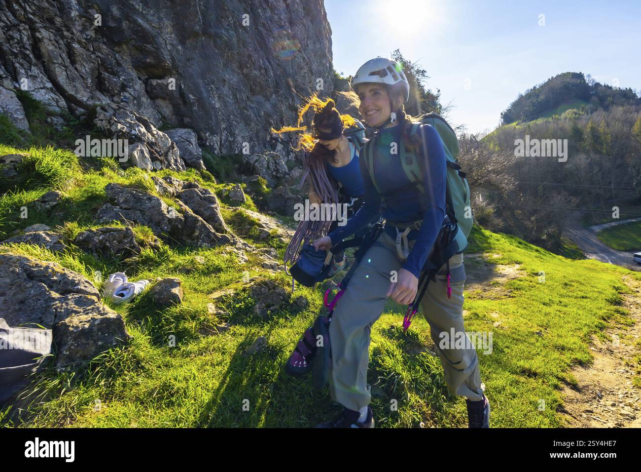 Two young women walking down a mountainside after a climbing session ...