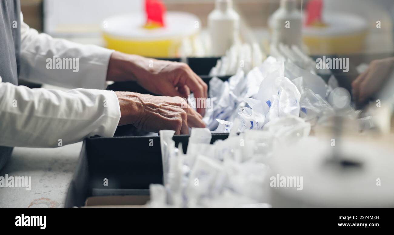 Doctor, medicine and inventory sorting with hands and IV bags for ...
