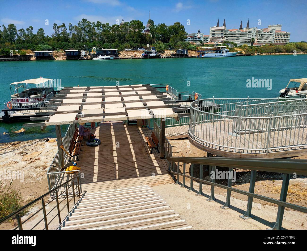 View of the wooden stairs to the river pier with anchored small boats ...