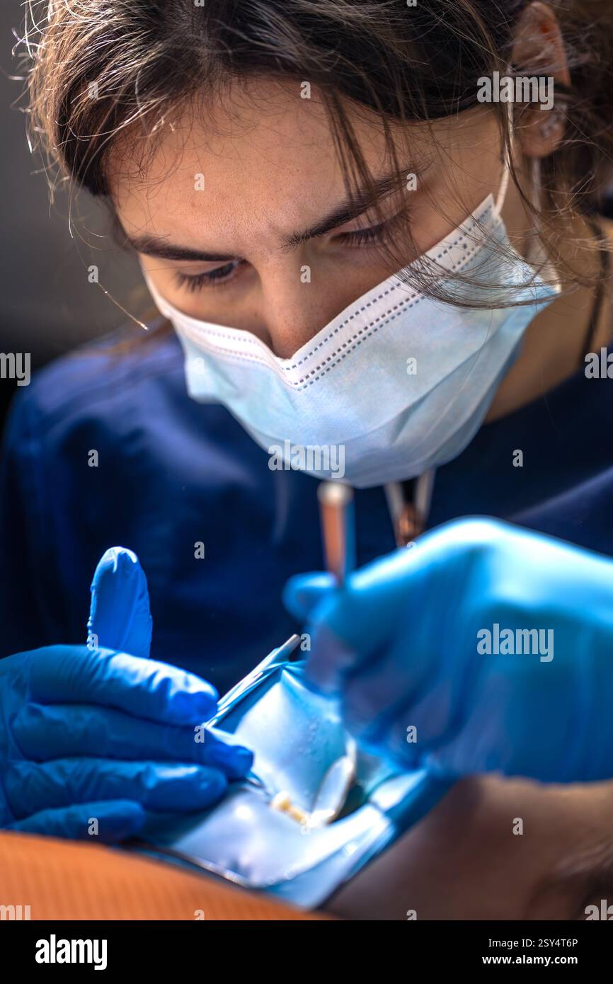 The dentist treats the child's tooth using a rubber dam. Close-up of ...