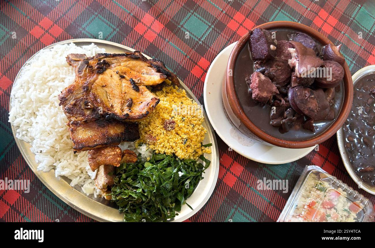 Traditional brazilian lunch featuring grilled pork, feijoada, rice ...