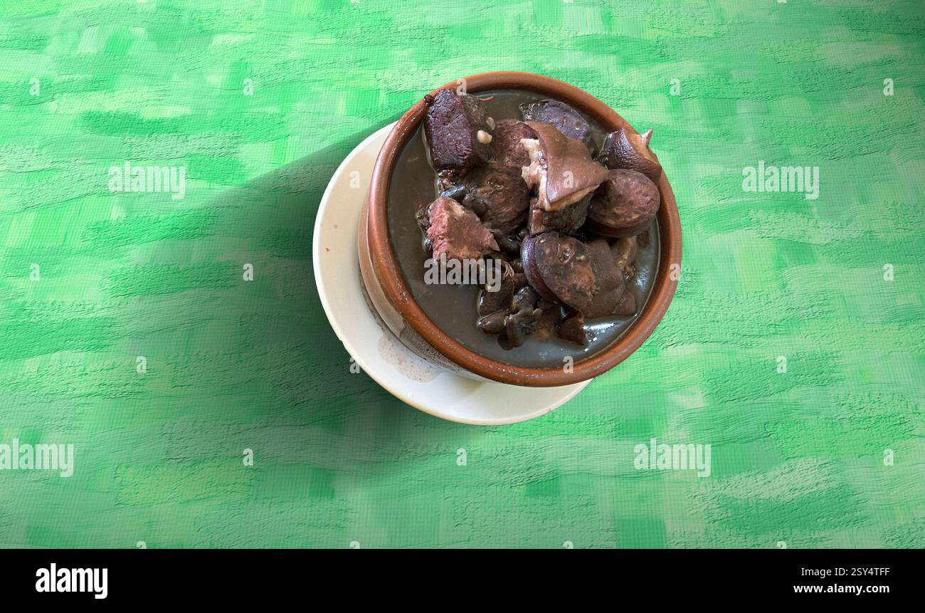 Traditional brazilian lunch featuring grilled pork, feijoada, rice ...