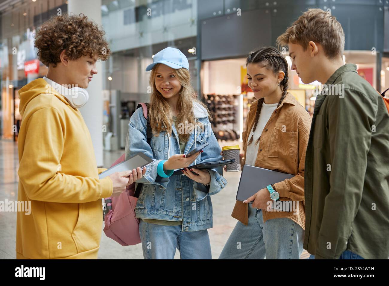 Group of diverse teenagers walking through shopping mall hall Stock ...