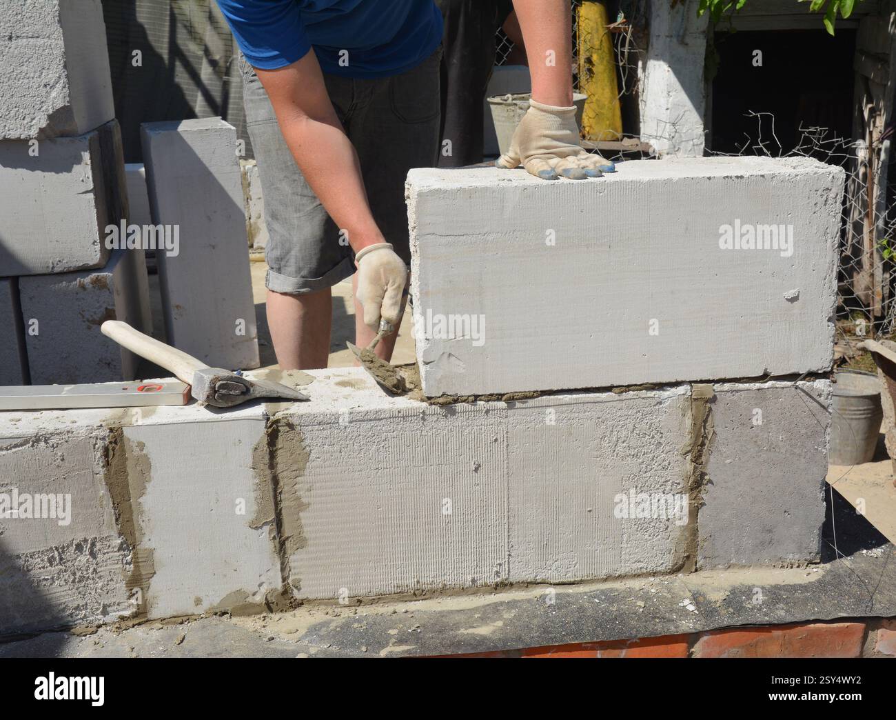 Bricklayer builder laying autoclaved aerated concrete blocks, aac for new house wall. Autoclaved ...