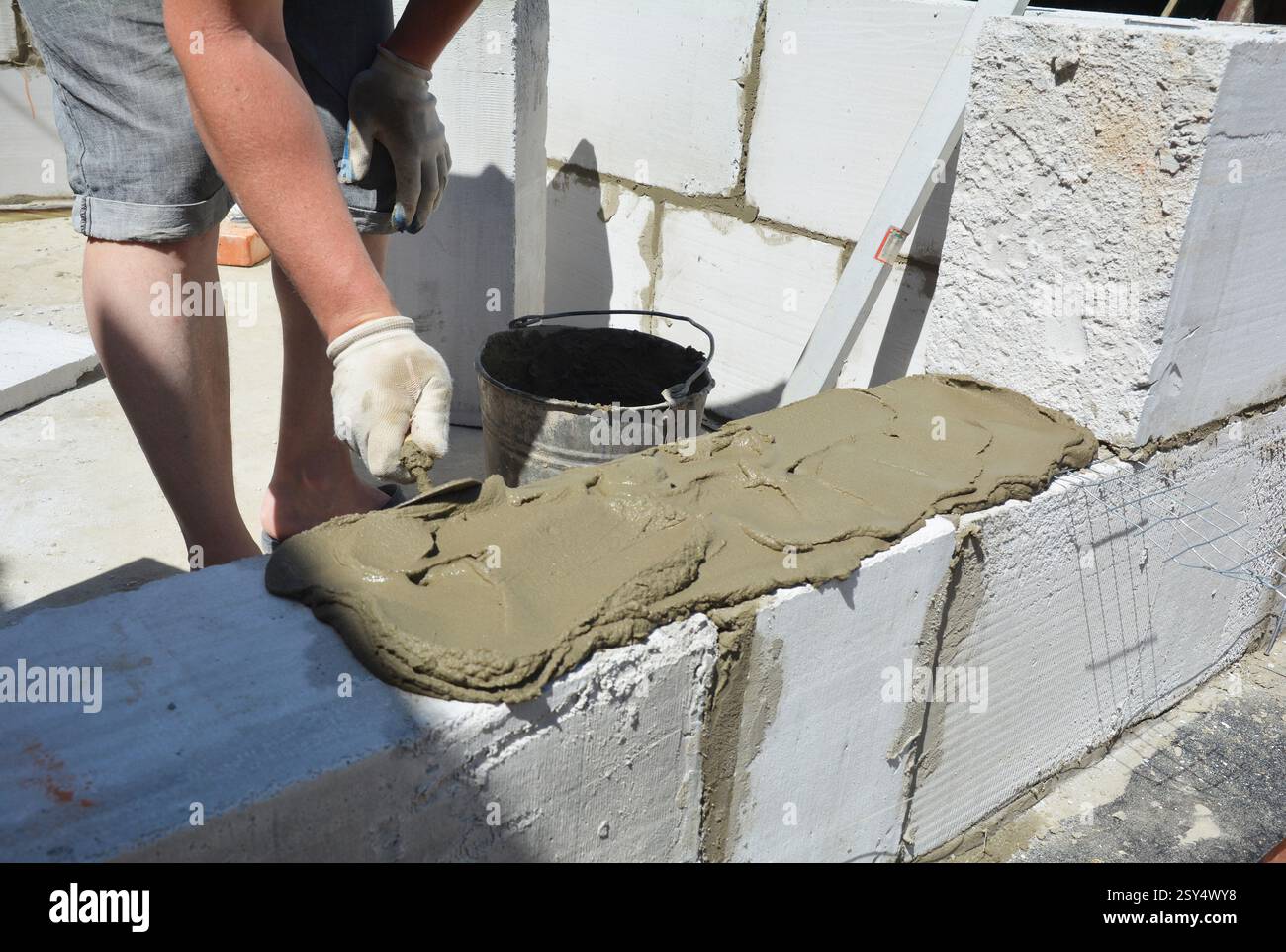 Bricklayer builder laying autoclaved aerated concrete blocks, aac ...
