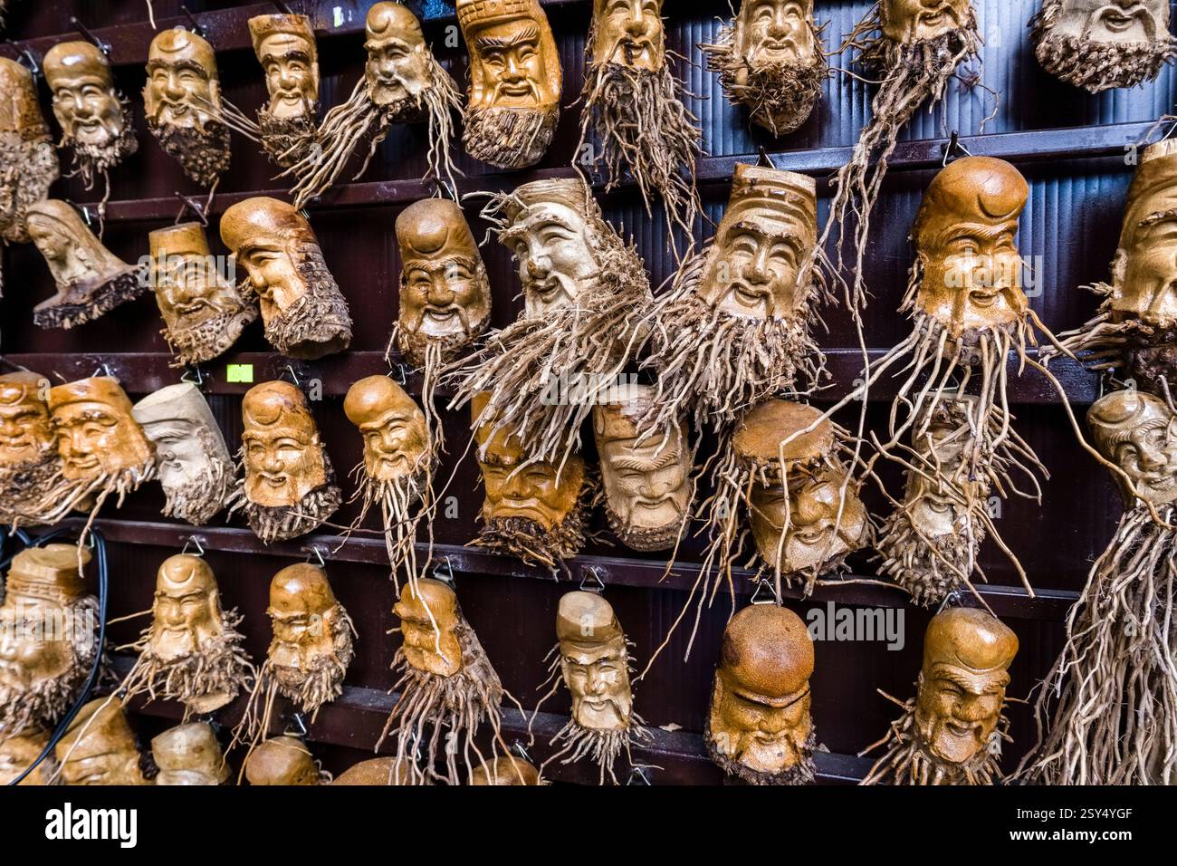 Small heads out of bamboo wood with roots, carved by an artist on a ...