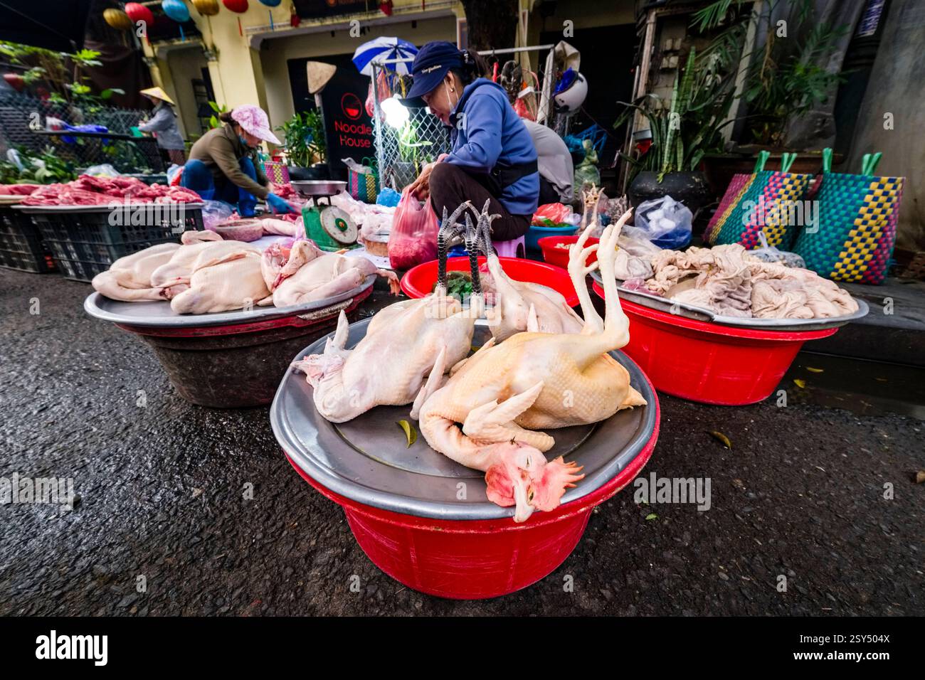 Women selling fresh chickens at one of the many street markets in the centre of Hoi An, Hái An ...