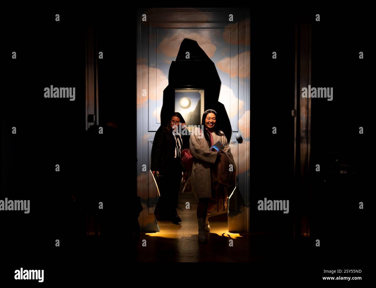 People walk through a broken door infront of the piece 'La ...