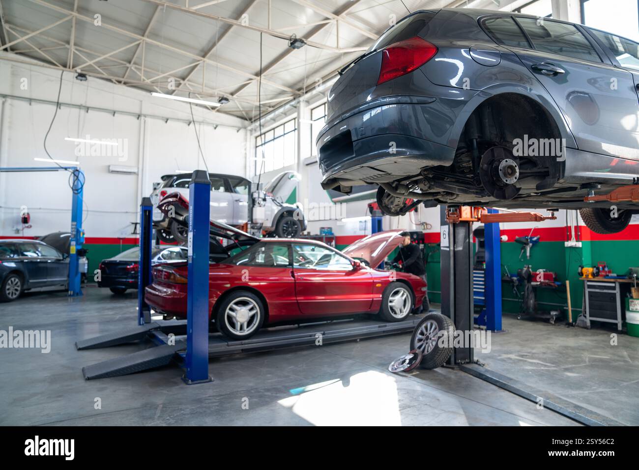 Car service workshop with cars on a column lifts Stock Photo - Alamy