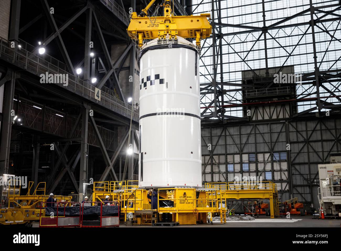Technicians with NASA’s Exploration Ground Systems use a crane in the ...