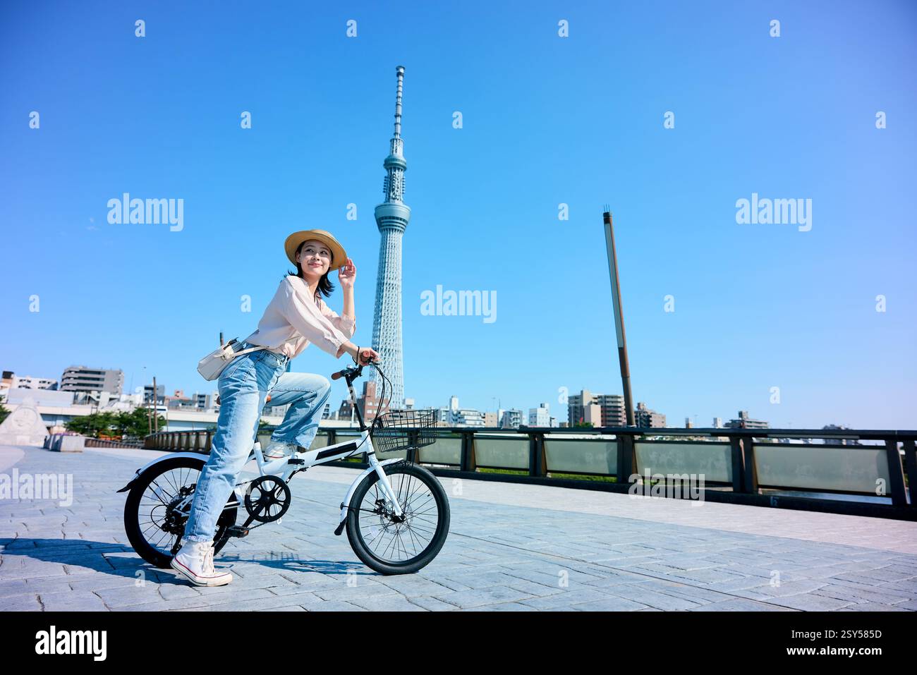 Japanese Woman Riding A Bike Near Tokyo Skytree Tower Stock Photo - Alamy