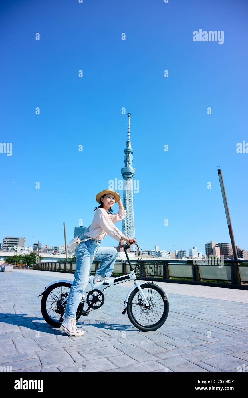 Japanese Woman Riding A Bike Near Tokyo Skytree Tower Stock Photo - Alamy
