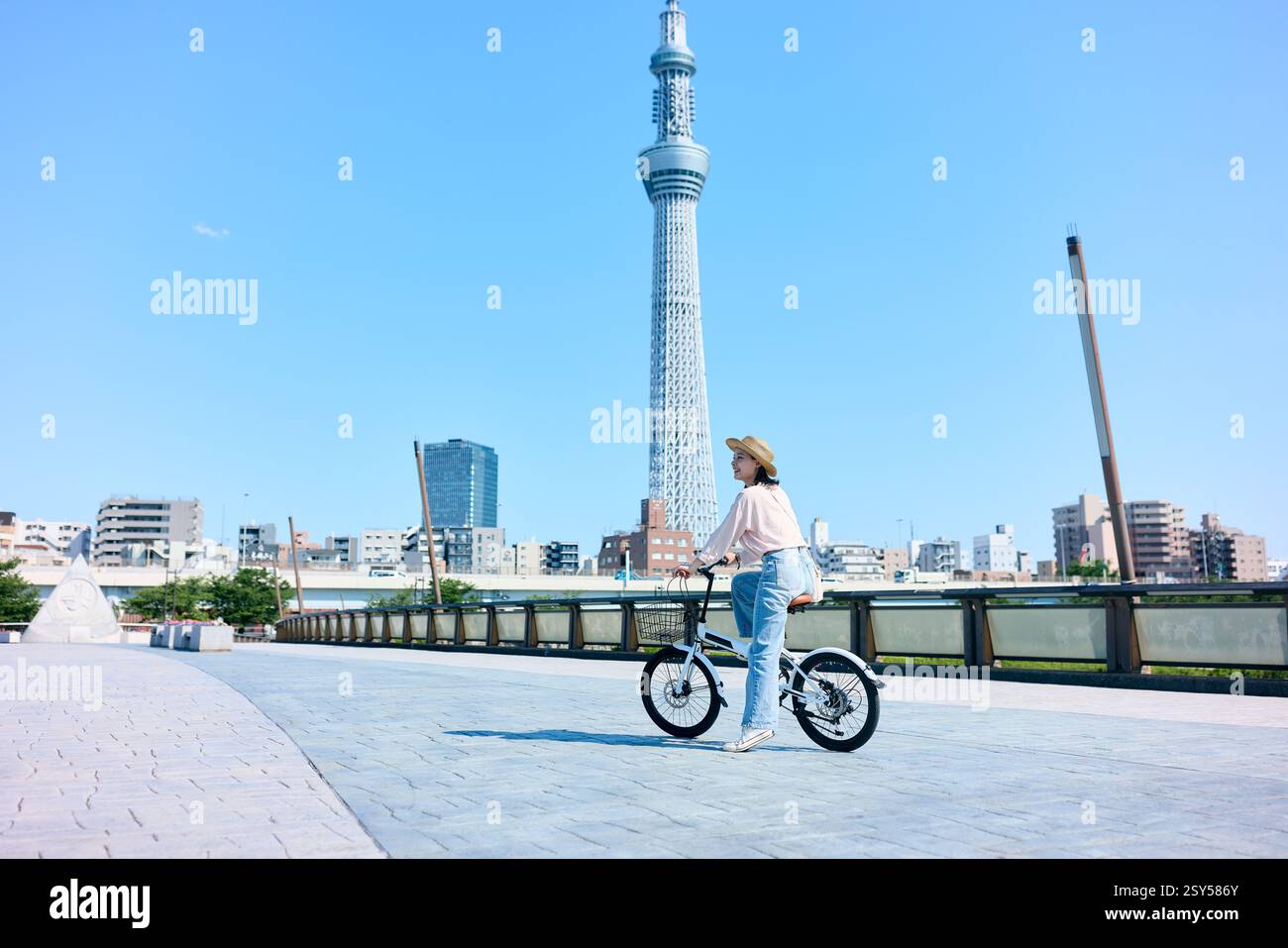 Japanese Woman Riding A Bike Near Tokyo Skytree Tower Stock Photo - Alamy