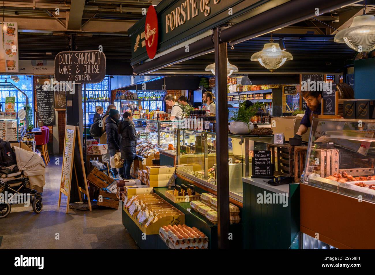 Inside Mathallen Oslo, an old industrial building converted to a food market with small ...