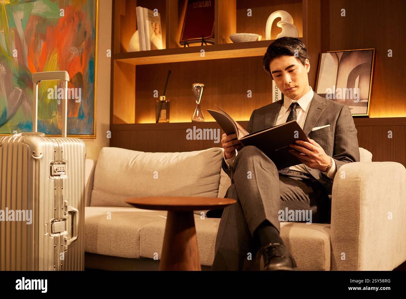 Japanese Man Sitting On A Couch Reading A Book Stock Photo - Alamy