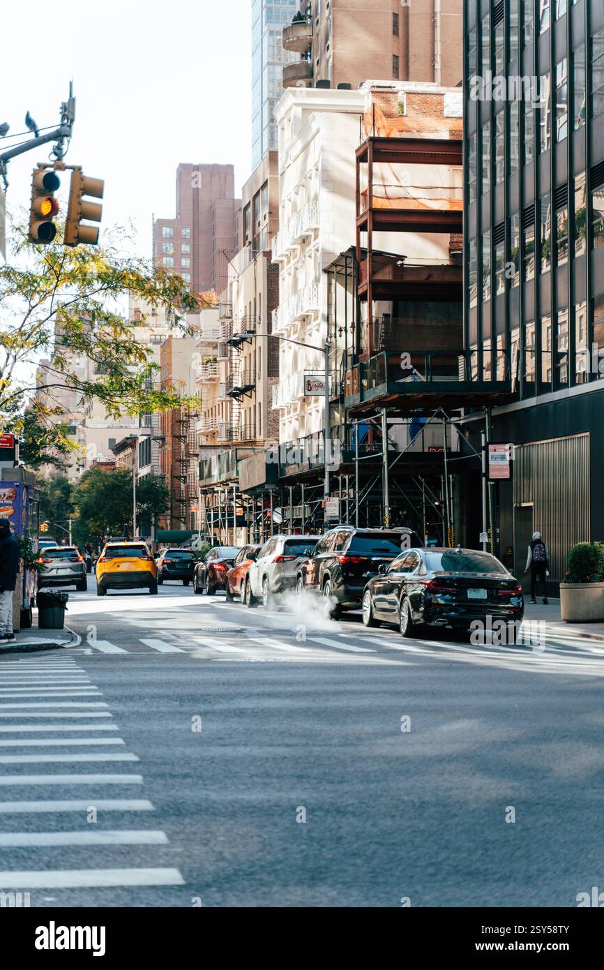 In busy Midtown East, Manhattan, cars maneuver through the crosswalk ...