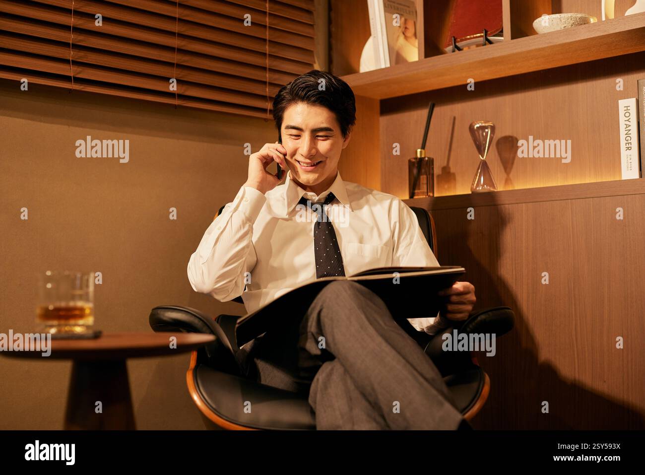 Japanese Man Sitting On A Chair Talking On The Phone Stock Photo - Alamy