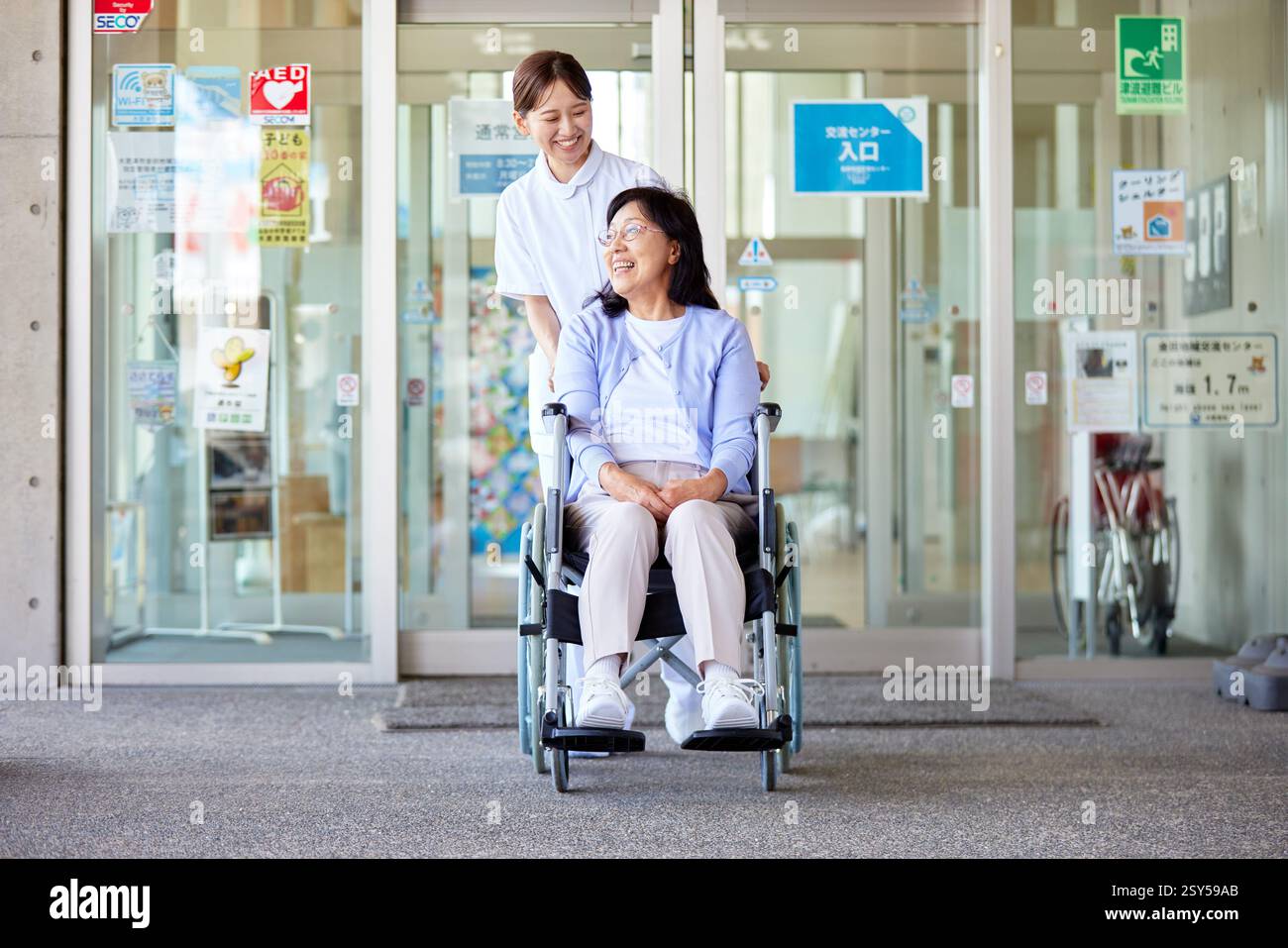 Japanese Woman In A WheelChair Being Pushed By A Nurse Stock Photo - Alamy
