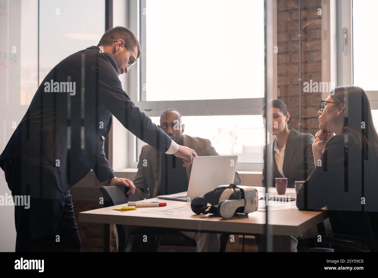 Business meeting in a modern office with a man in a suit presenting ...
