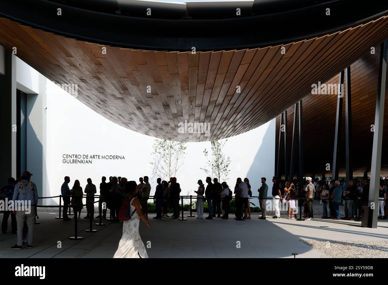Visitors gather beneath the curved wooden canopy of the Centro de Arte ...